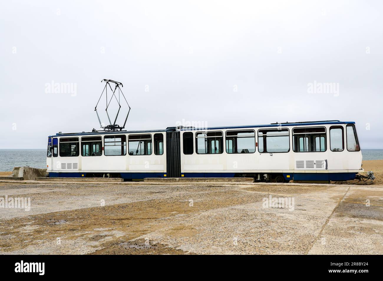 A used white electric tram car on the shore of the Baltic Sea for ...