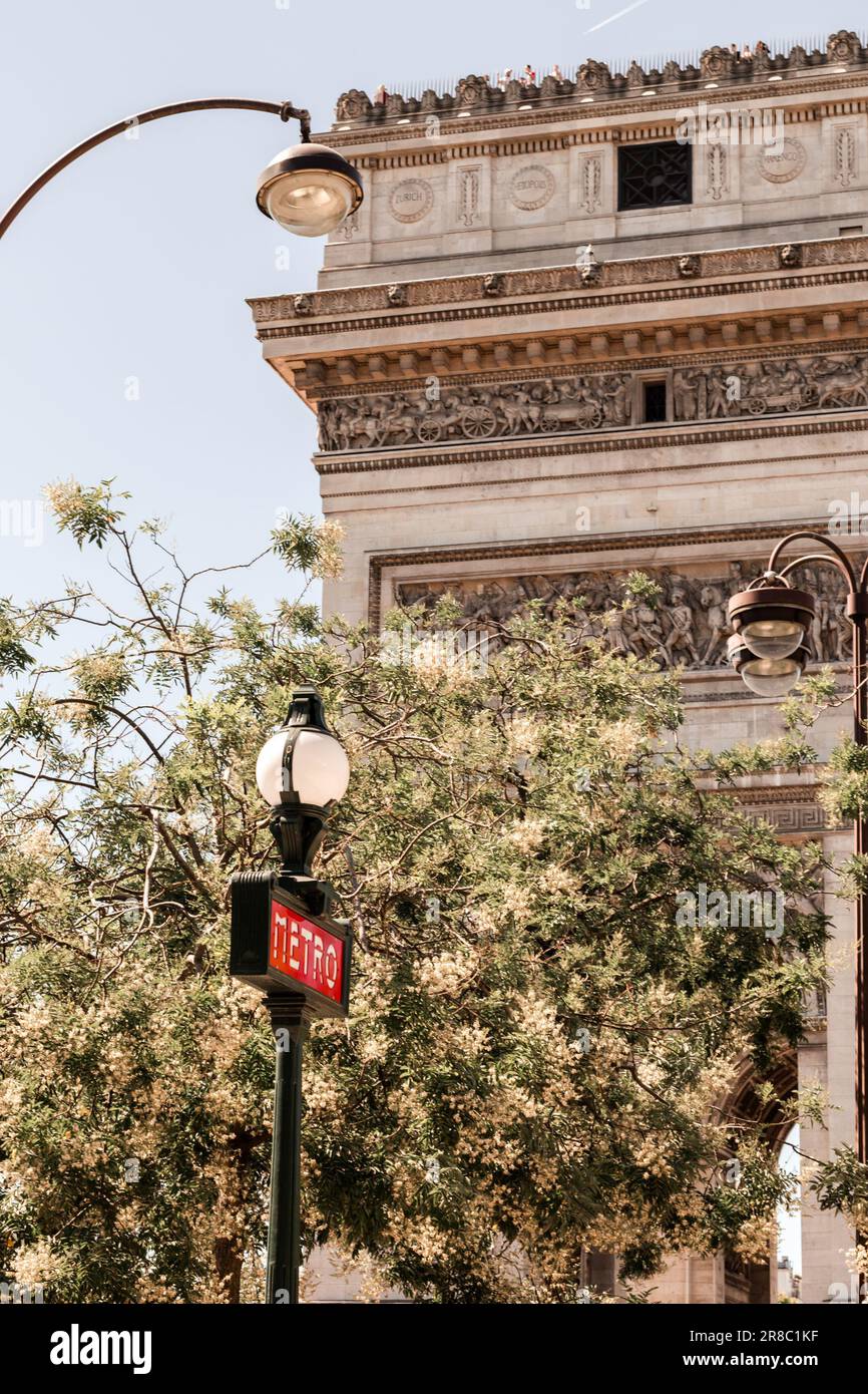 A scenic vertical shot of the Parisian street lamps with the iconic Arc ...