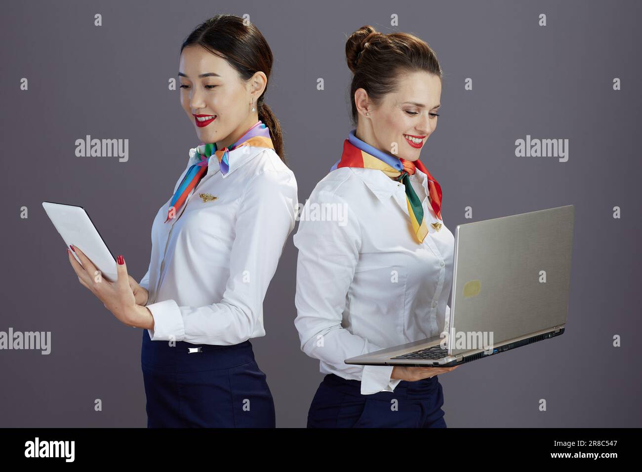 smiling stylish flight attendant women in blue skirt, white shirt and ...