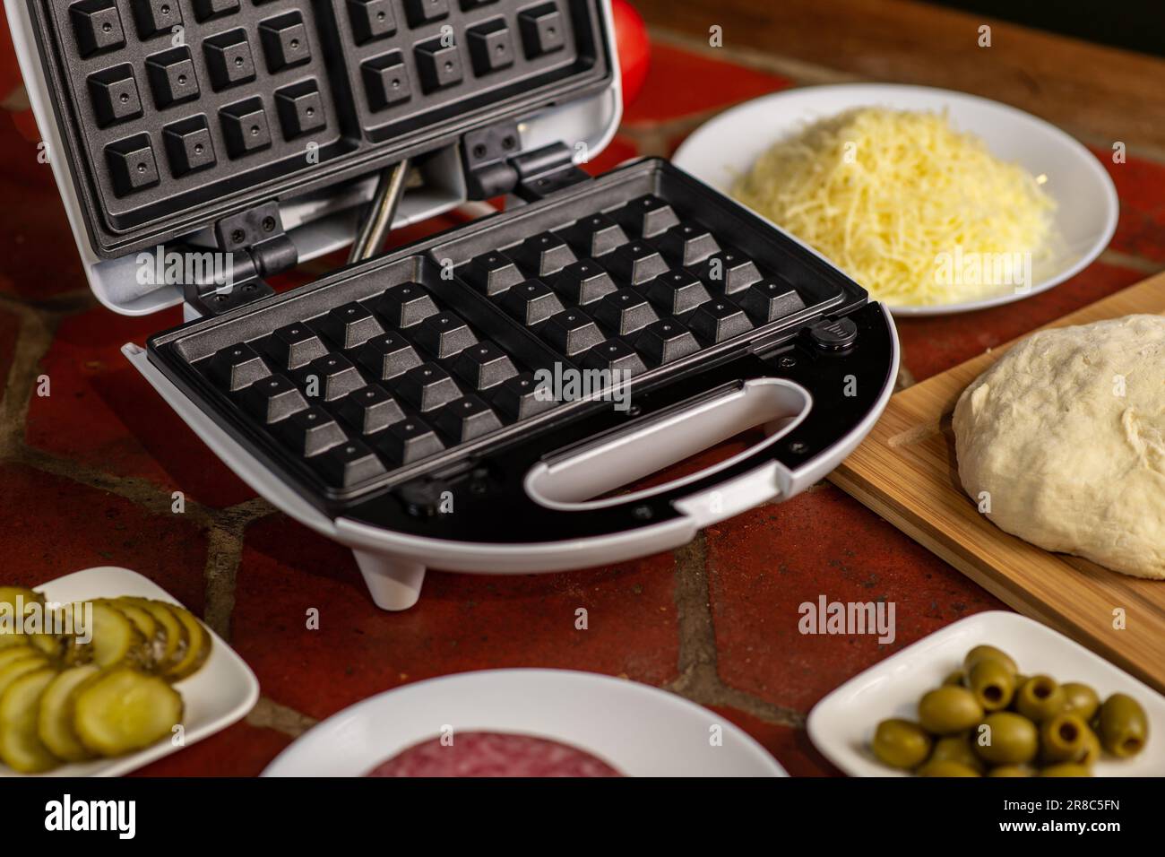 Cooking pizza waffle, piffle. Different ingredients - sausage, olives ...