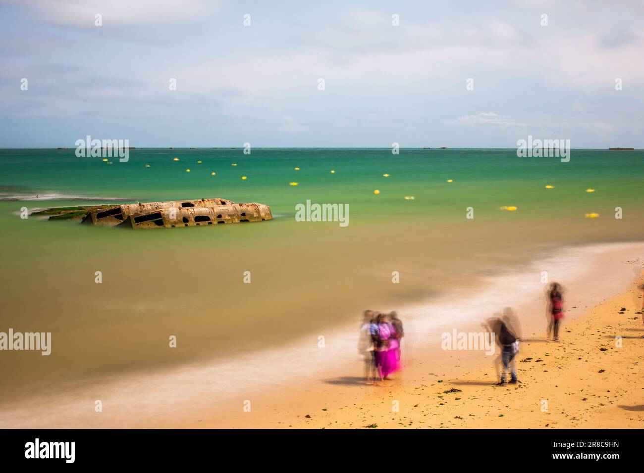 Tourists taking pictures in fronit of the remains of a WW2 Mulberry ...