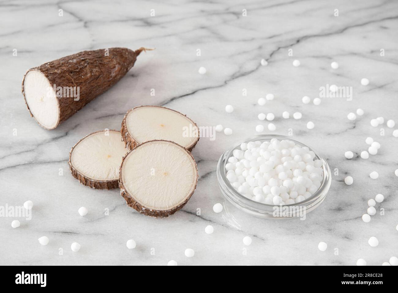 Close-up of a cassava root on a white background with tapioca pearls ...