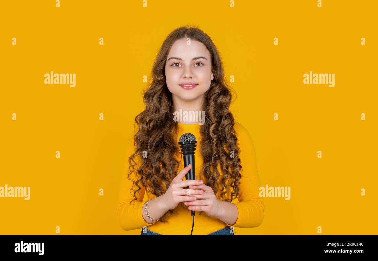 teen girl hold microphone on yellow background. Singer Stock Photo - Alamy