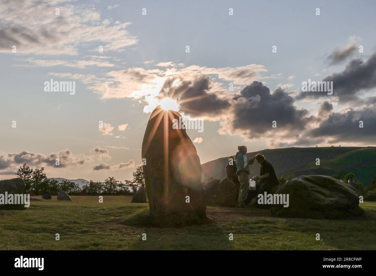 The sun sets over a stone at Castlerigg Stone Circle Summer Solstice ...