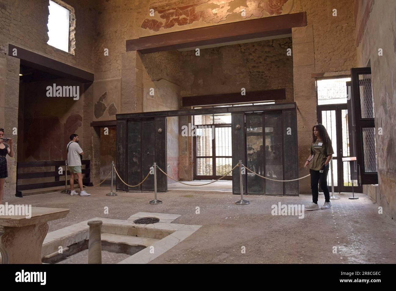 Tourists viewing a building with preserved wooden doors in the Roman ...