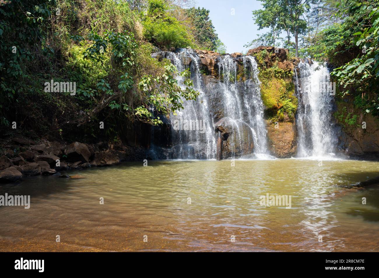 A landscape of the Katieng waterfall surrounded by greenery in Banlung ...