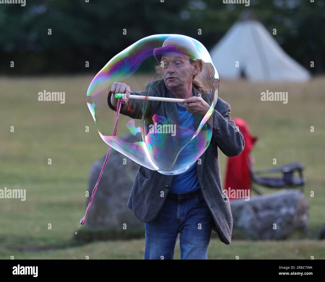 A person blows bubbles as he entertains people in the centre of the ...