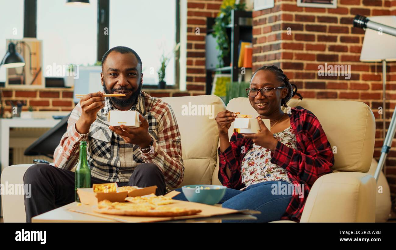 African american people eating noodles with chopsticks and binge ...