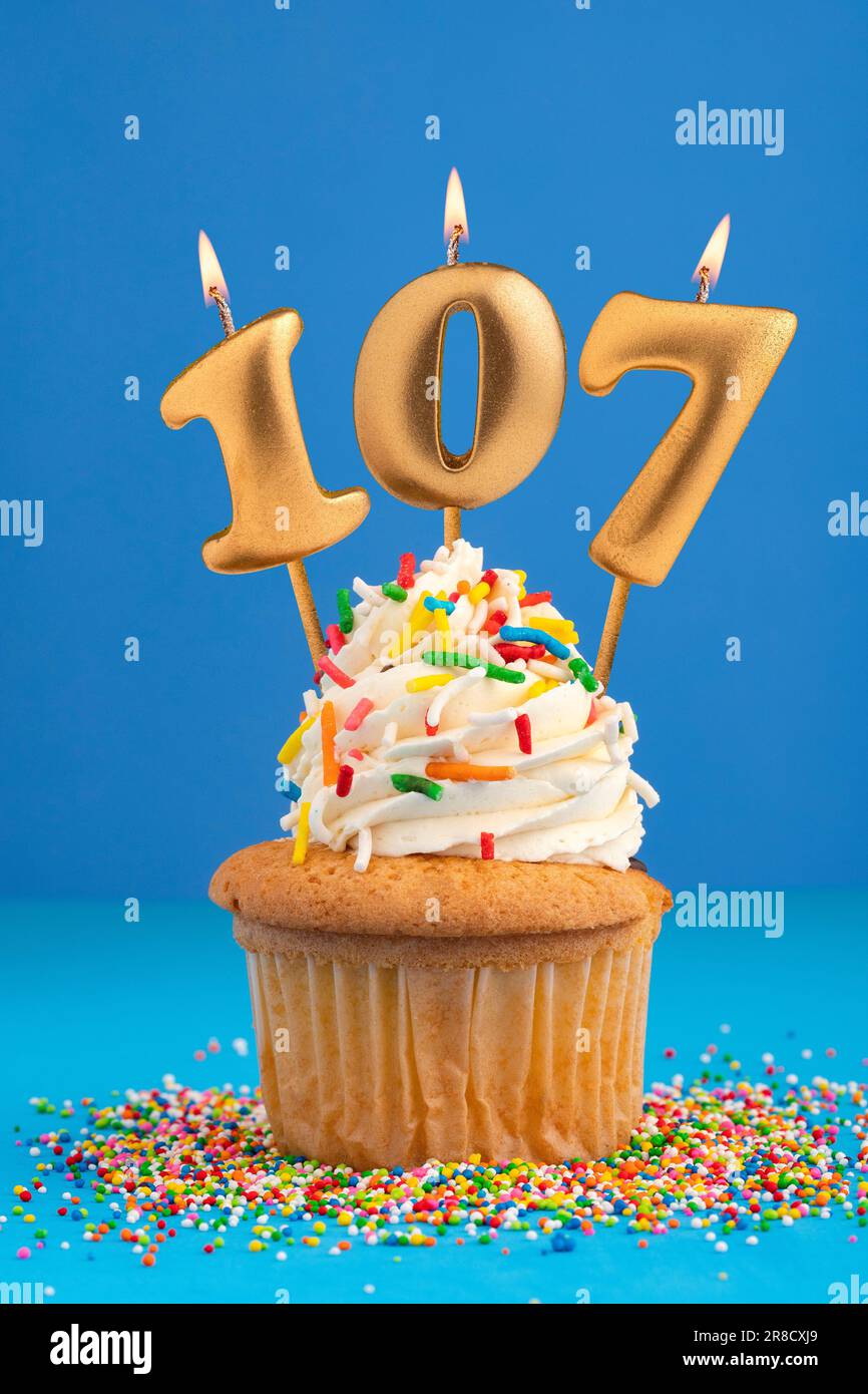 Candle number 107 - Cake birthday in blue background Stock Photo - Alamy