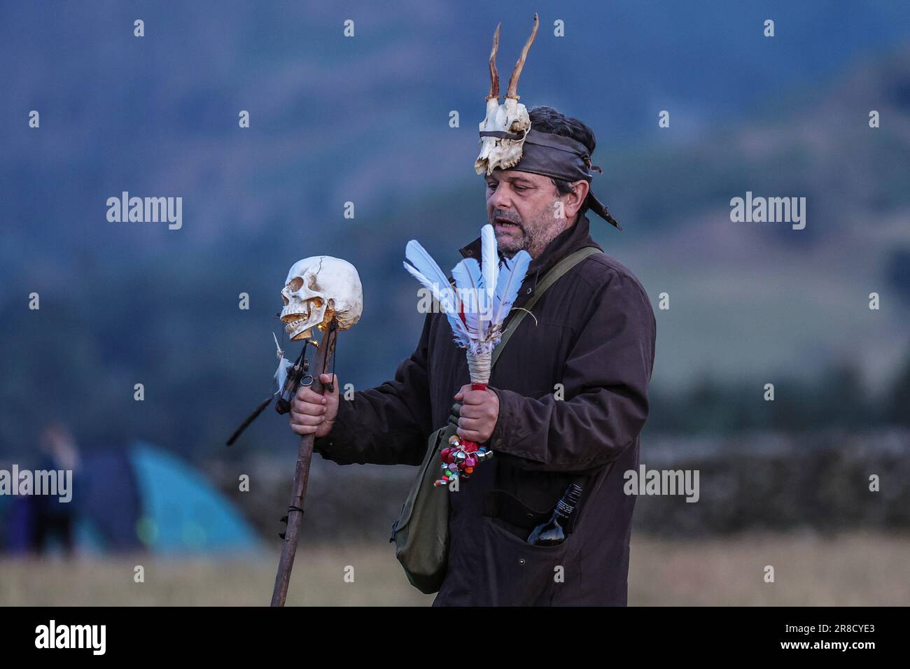 A person performs a spiritual ritual on one of the stones during the ...
