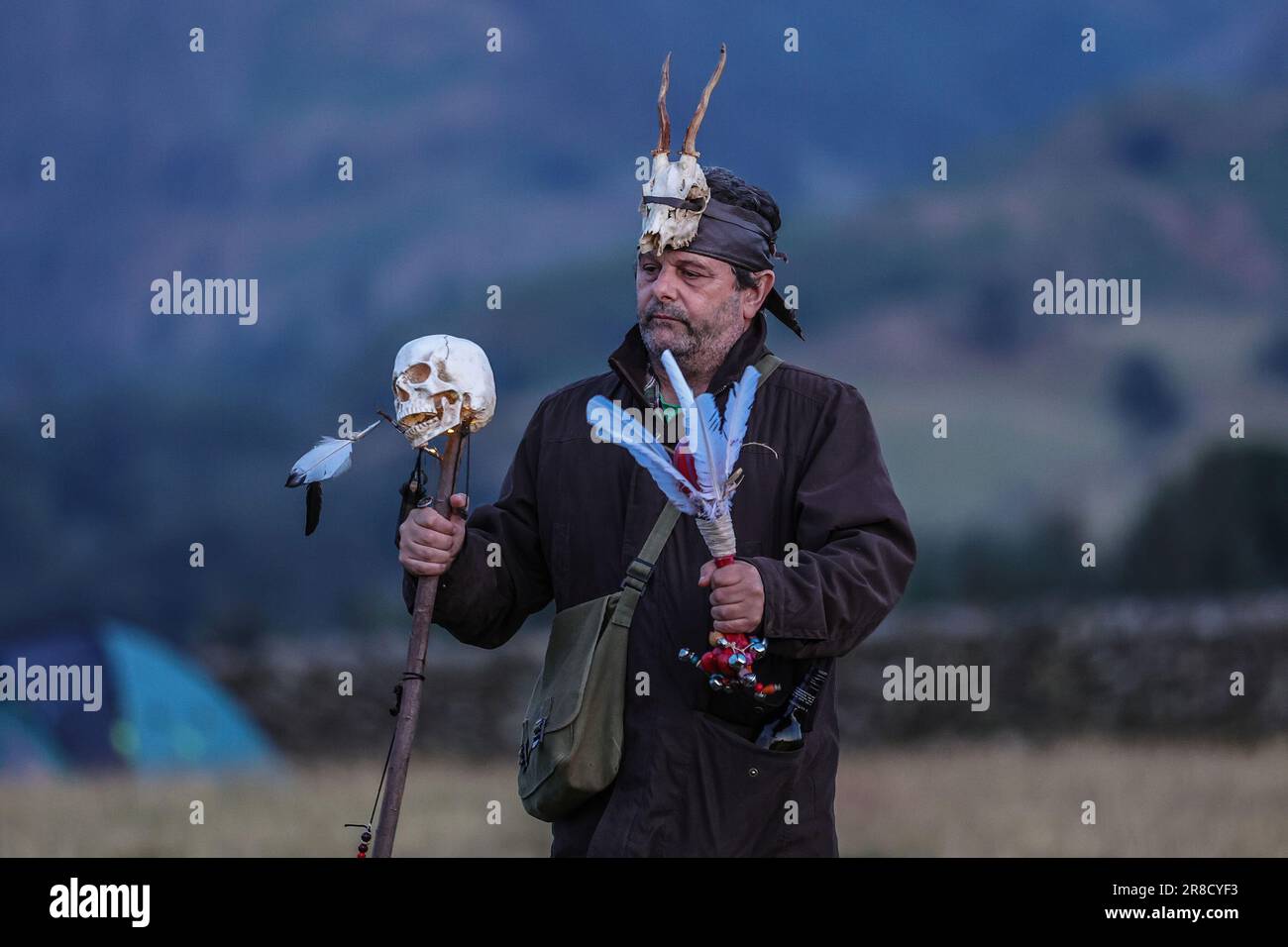 A person performs a spiritual ritual on one of the stones during the ...
