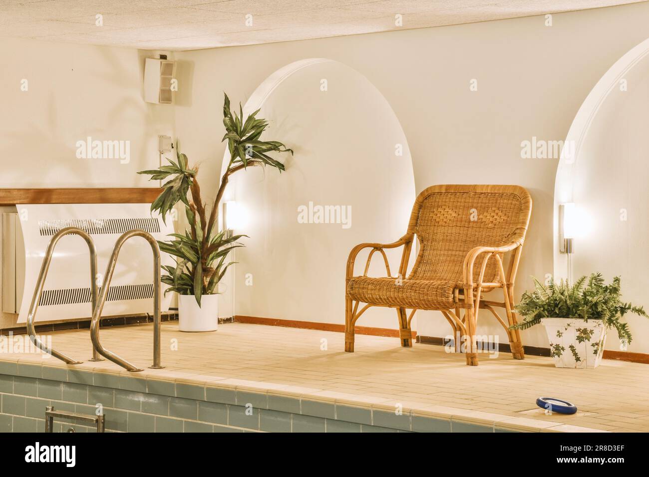 an indoor swimming pool with two chairs and a microwave oven in the ...