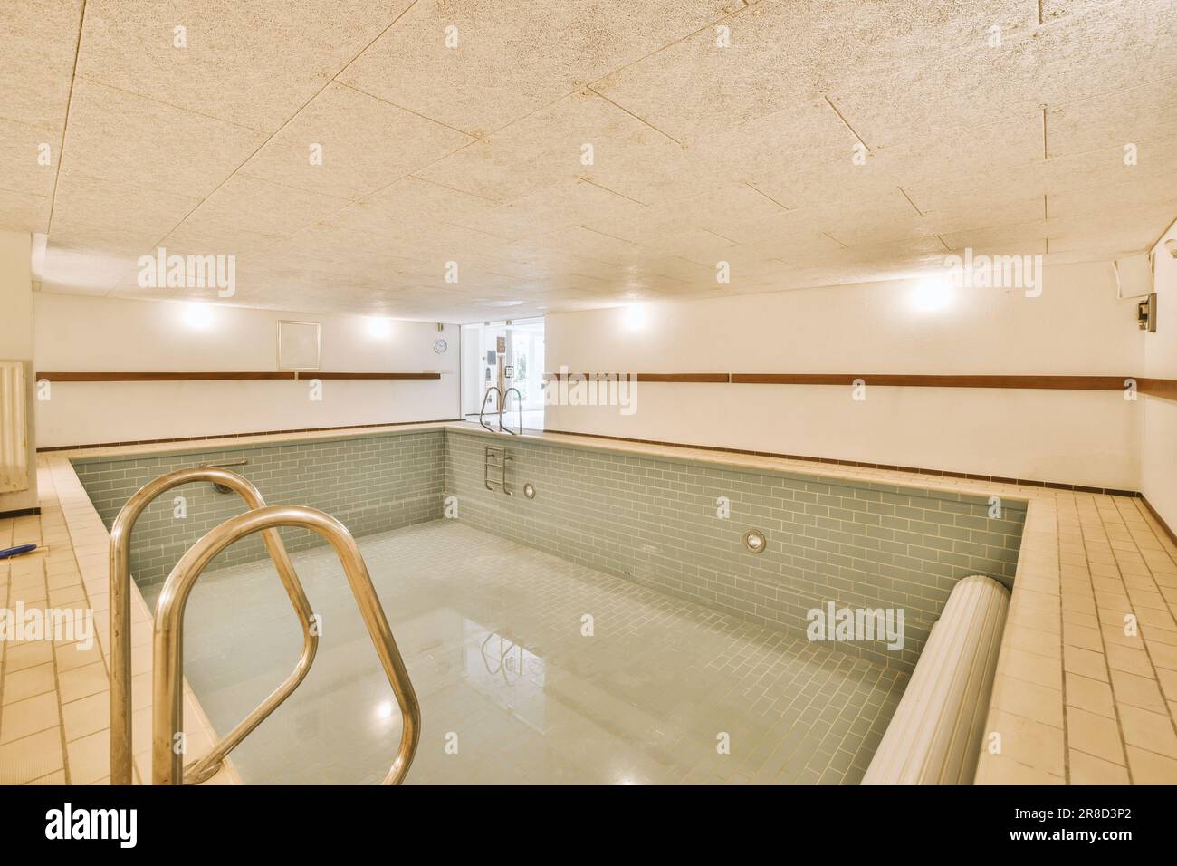 an indoor swimming pool with tiled walls and tile flooring in a room ...
