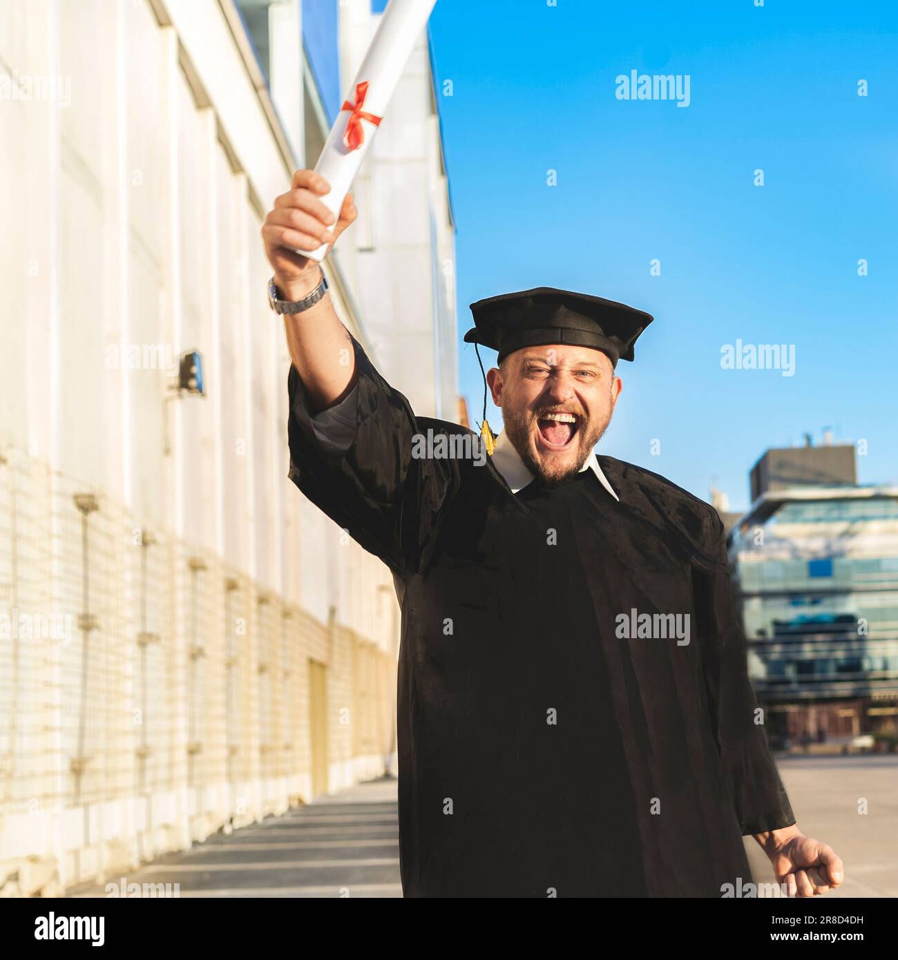 Happy graduated adult man wearing a bachelor gown and a black ...