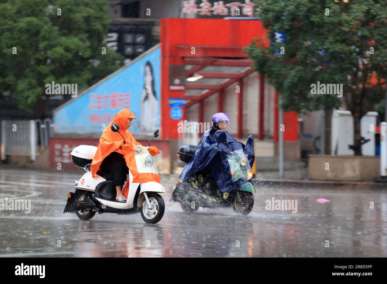 LIUZHOU, CHINA - JUNE 20, 2023 - Citizens travel wear ponchos in heavy ...