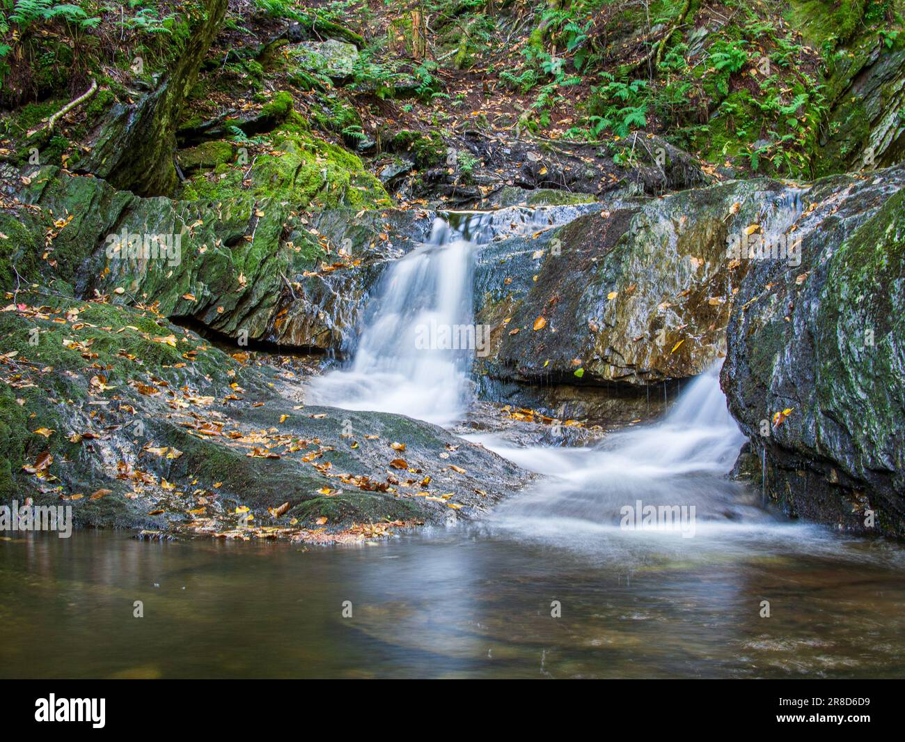 Smooth and silky water spills over a cliff in the Adirondack Mountains ...
