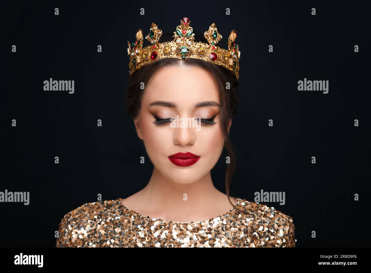 Beautiful young woman wearing luxurious crown on black background Stock Photo - Alamy