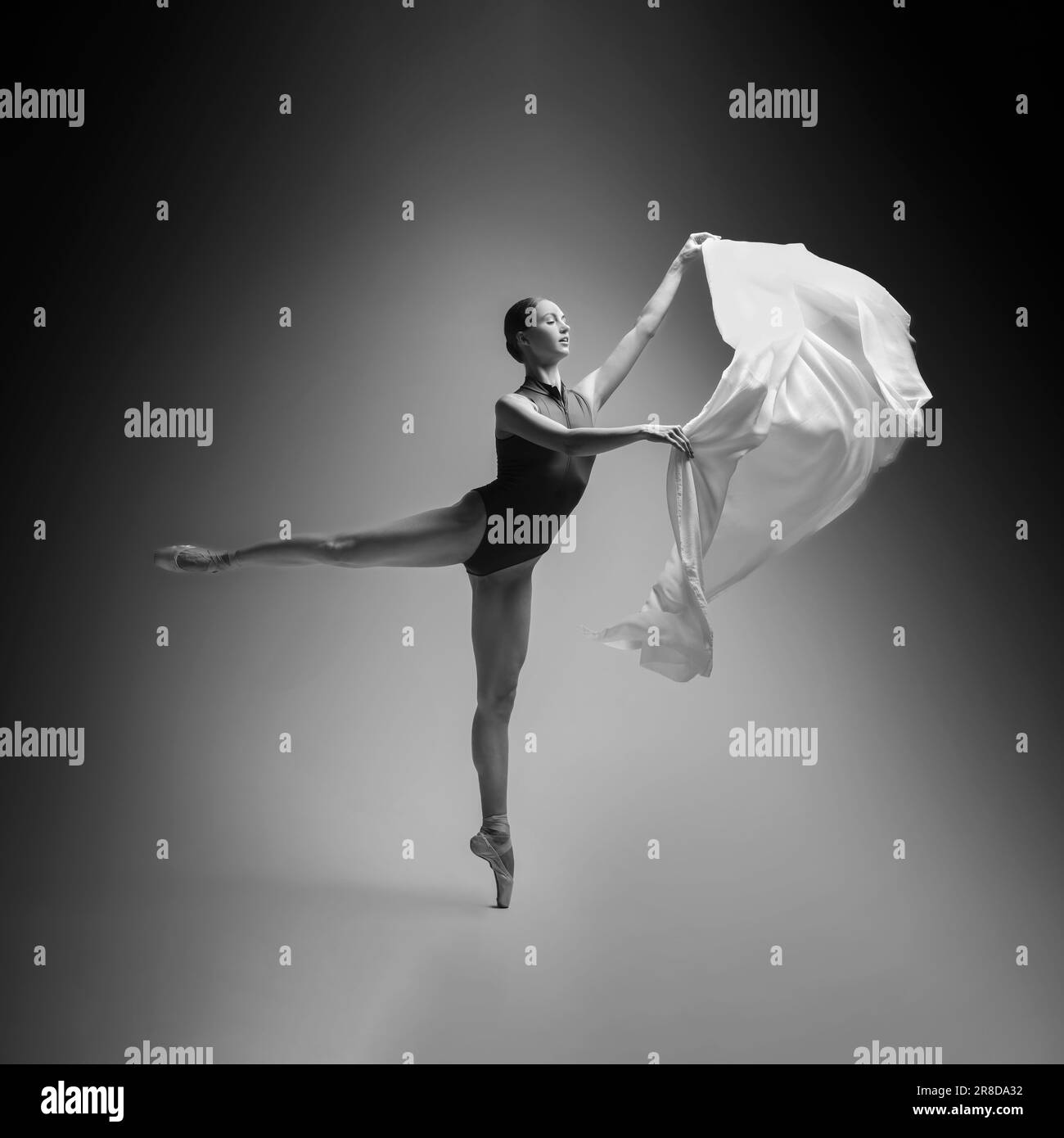 Graceful young ballerina practicing dance moves with veil. Black and ...