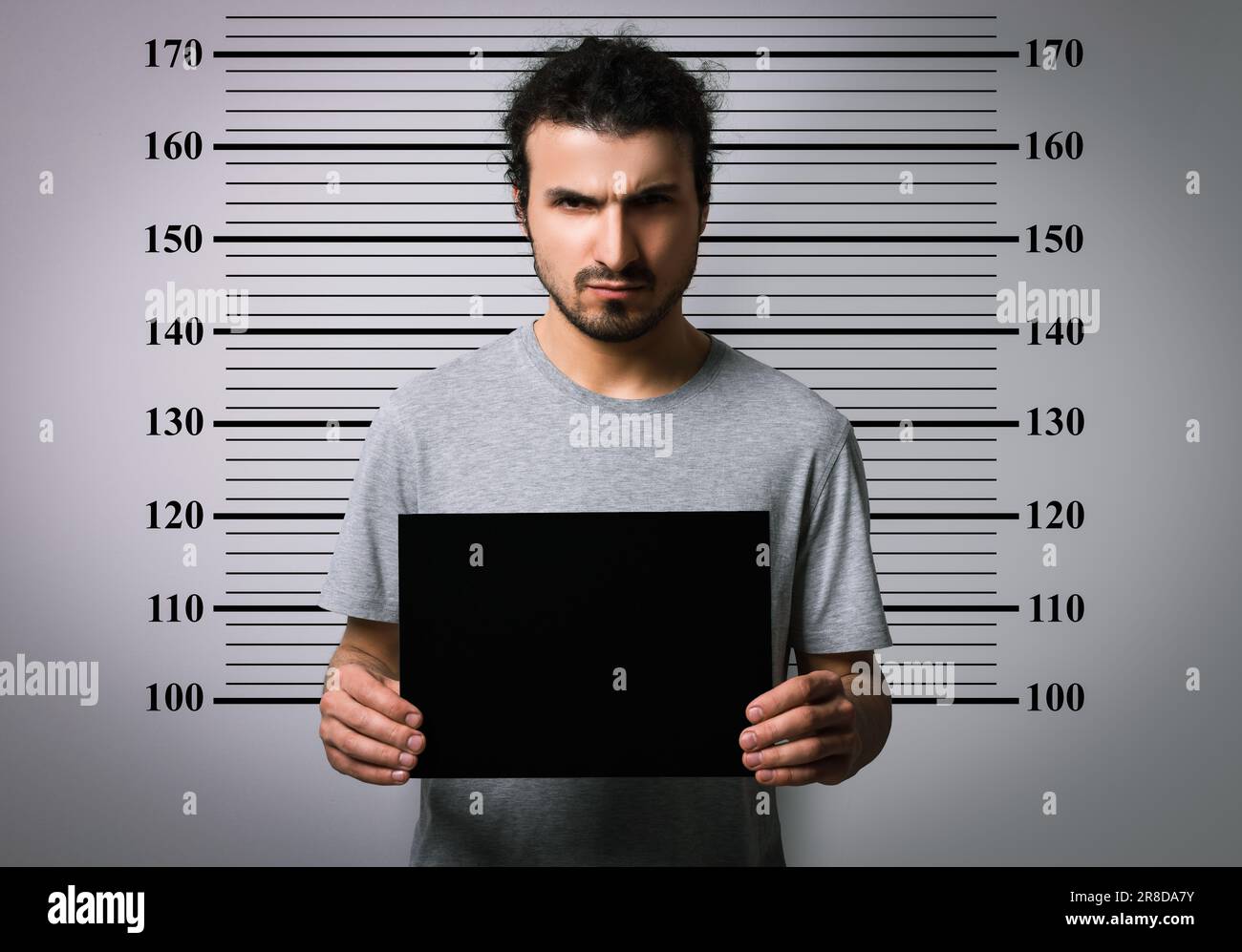 Criminal mugshot. Arrested man with blank card against height chart ...