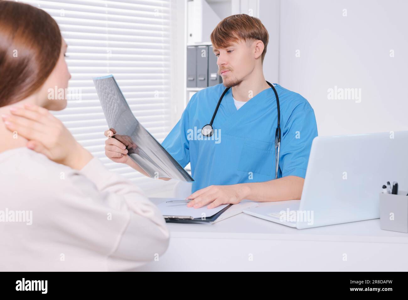Doctor with neck MRI image consulting patient in clinic Stock Photo - Alamy