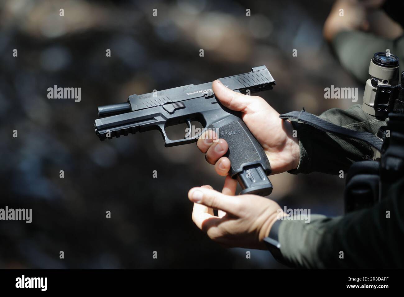 A Costa Rican special operations team member prepares his pistol before ...