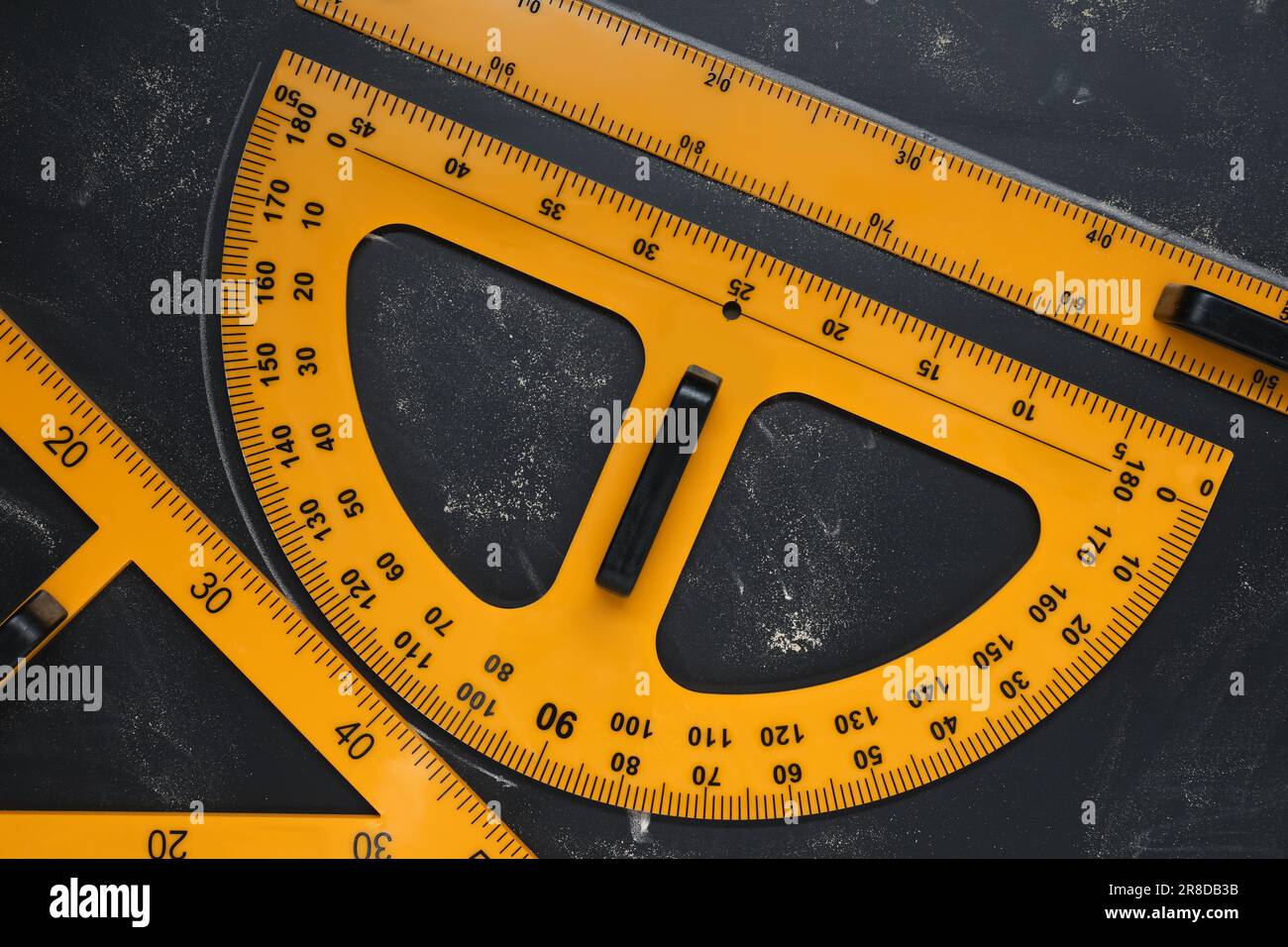 Protractor, ruler and triangle on blackboard, flat lay Stock Photo - Alamy