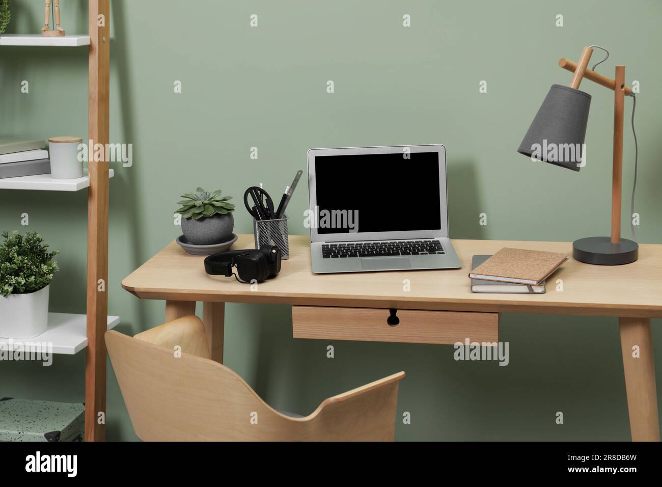 Workplace with laptop, stationery on desk and chair in home office ...