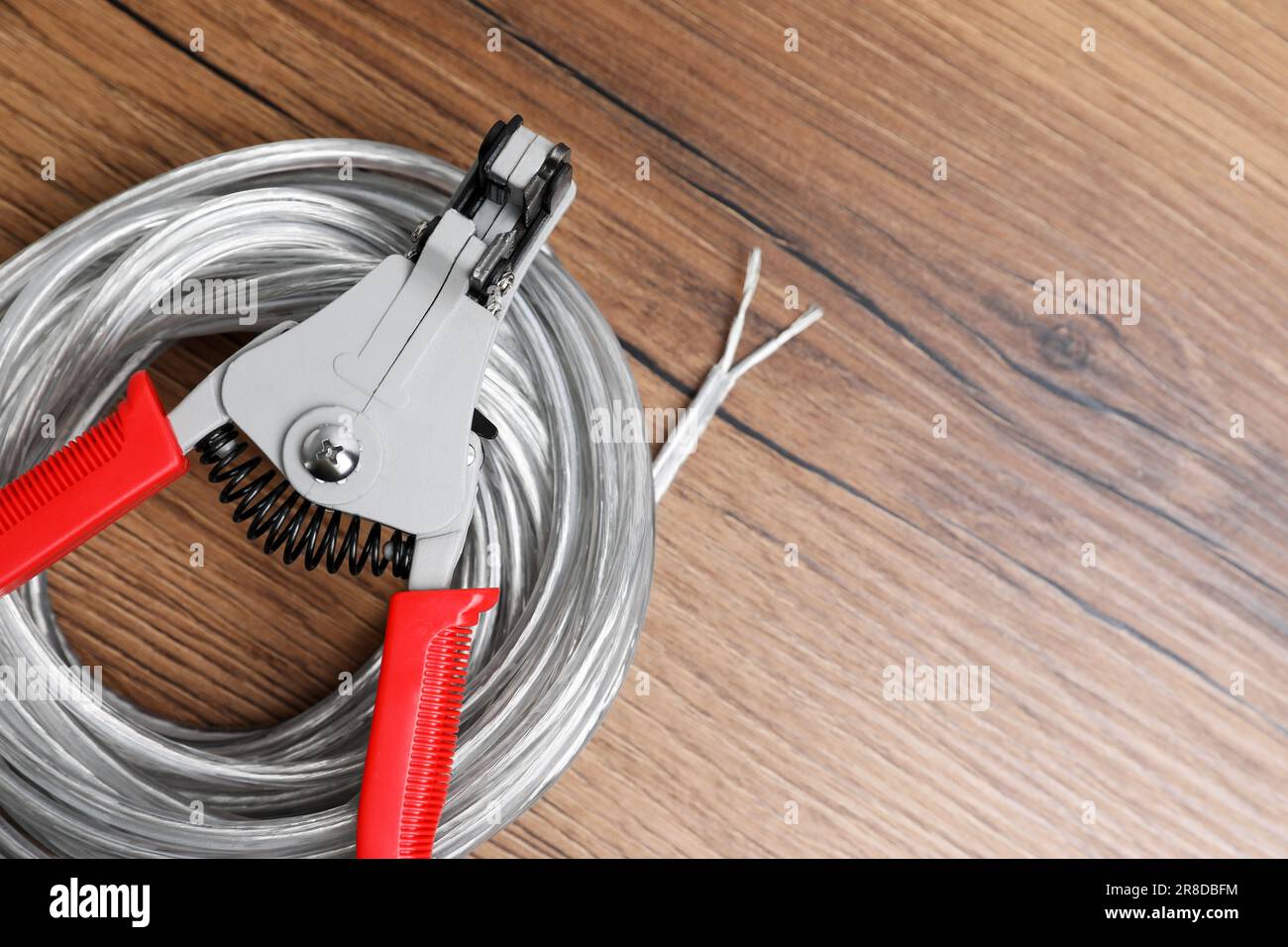 Cutters and cable with stripped wire on wooden table, top view. Space ...