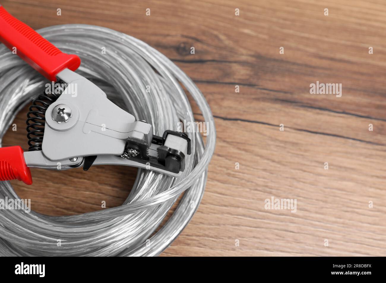 Cutters and cable with stripped wire on wooden table, closeup. Space ...