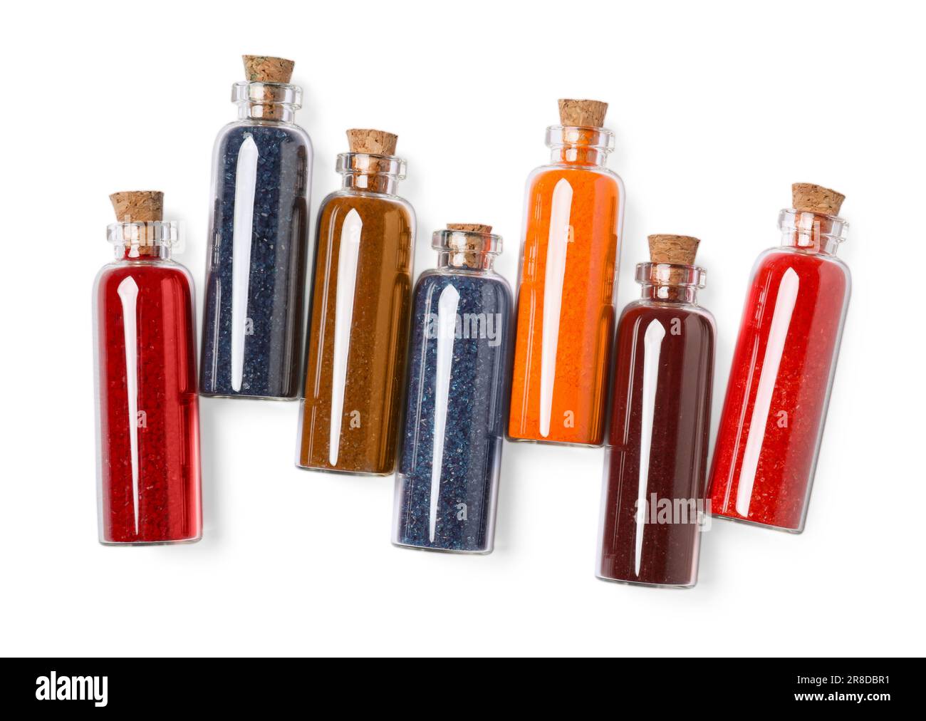 Glass bottles of different food coloring isolated on white, top view ...