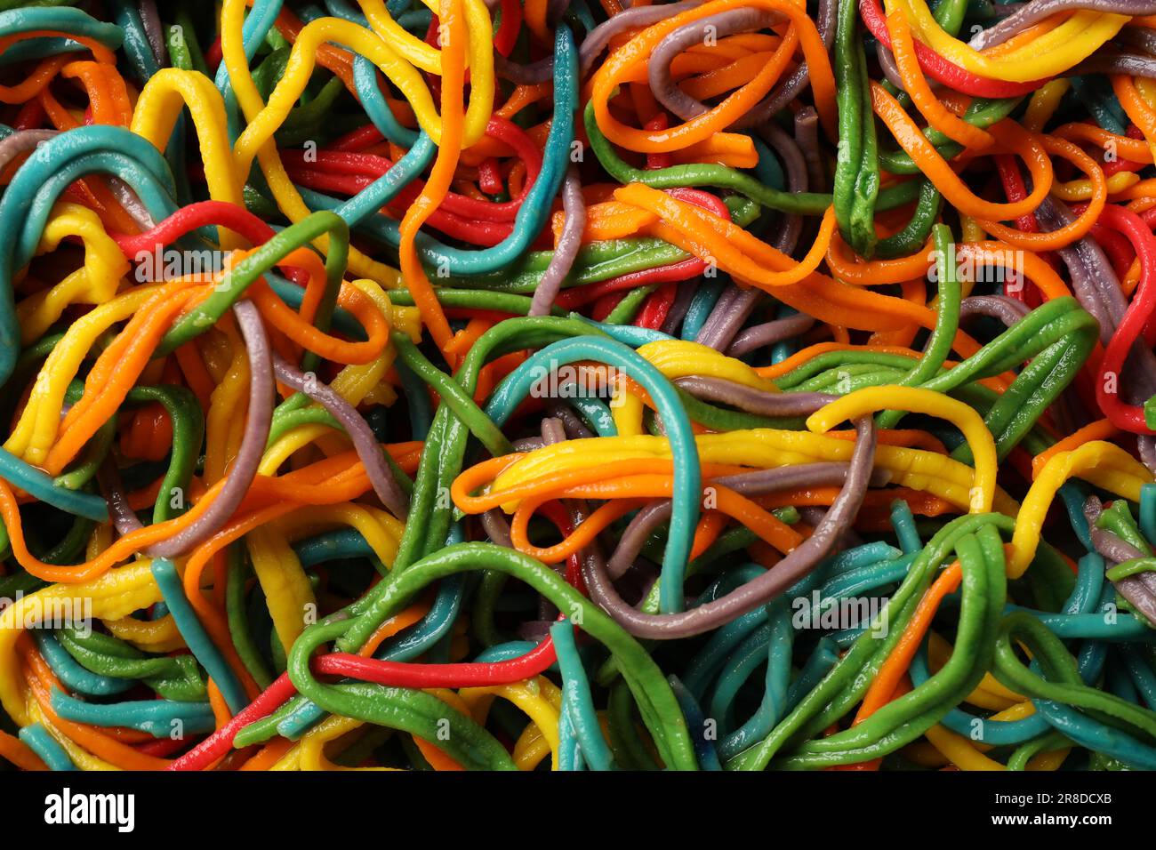 Spaghetti painted with different food colorings as background, closeup ...
