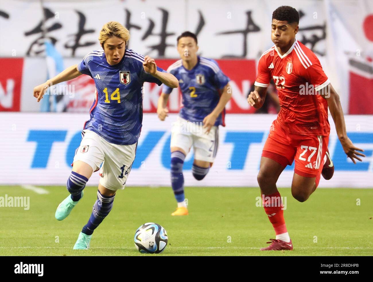 Suita, Japan. 20th June, 2023. Japan's Junya Ito (L) fights the ball ...