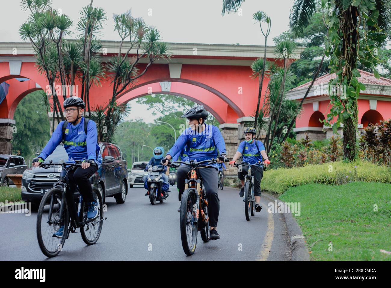 A group of asian men in blue shirts and wearing helmets are very ...