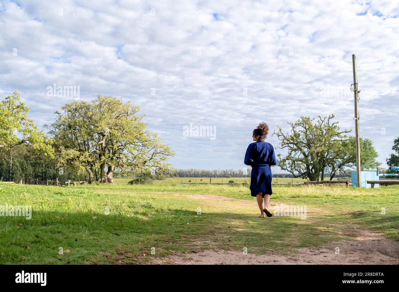 Woman walking outdoors in the field Stock Photo - Alamy