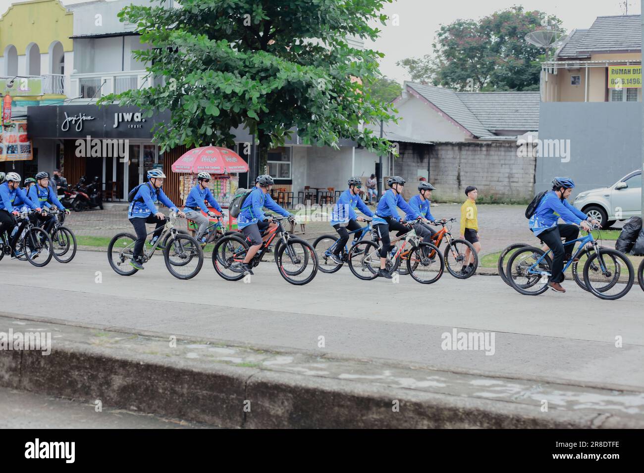 A group of asian men in blue shirts and wearing helmets are very ...