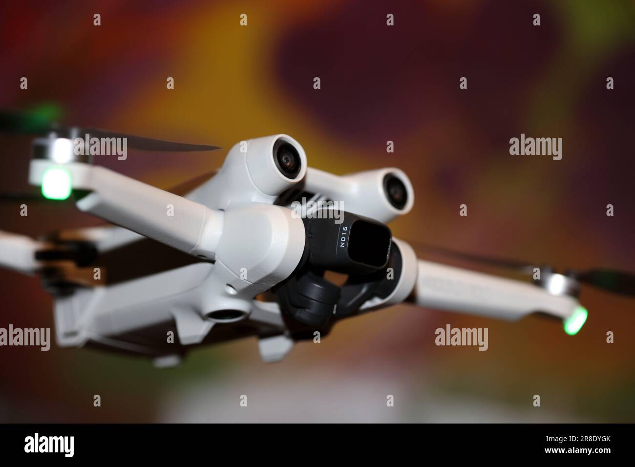 The drone copter flying with digital camera isolated on empty colorful ...