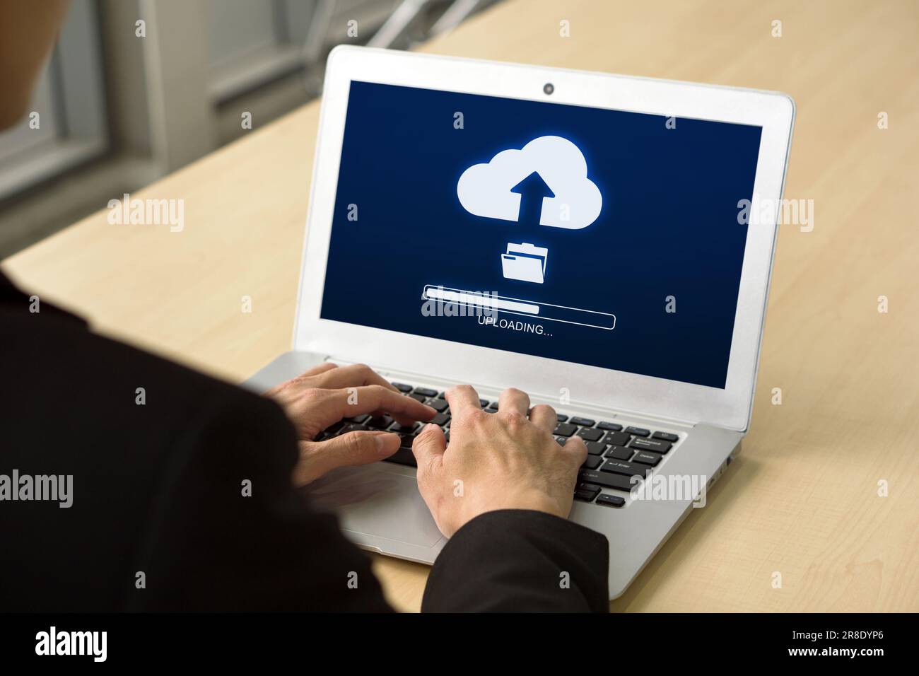 Back view of businessman using cloud drive technology upload save files to internet. Data ...