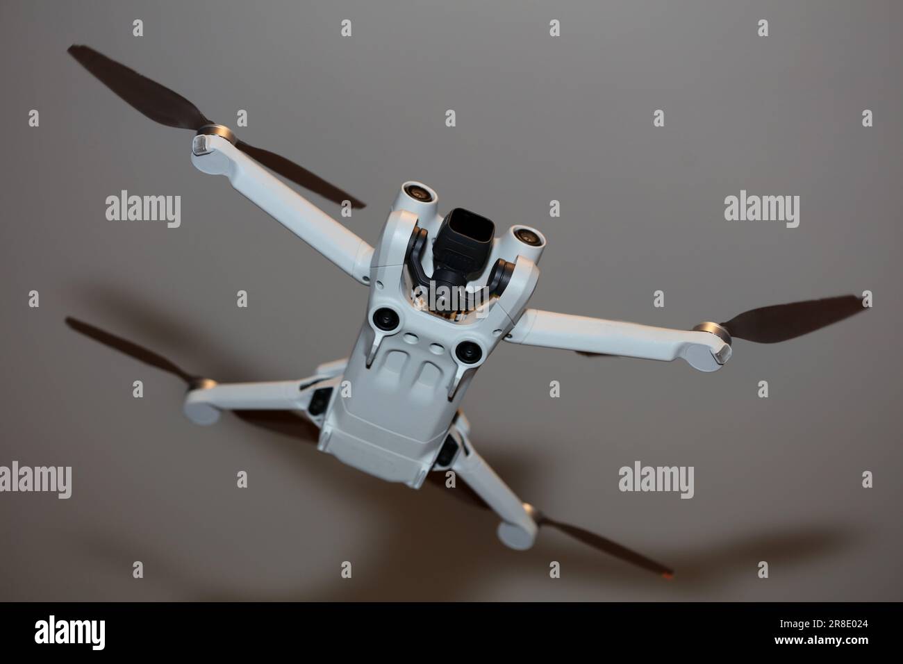 The drone copter flying with digital camera isolated on empty colorful ...