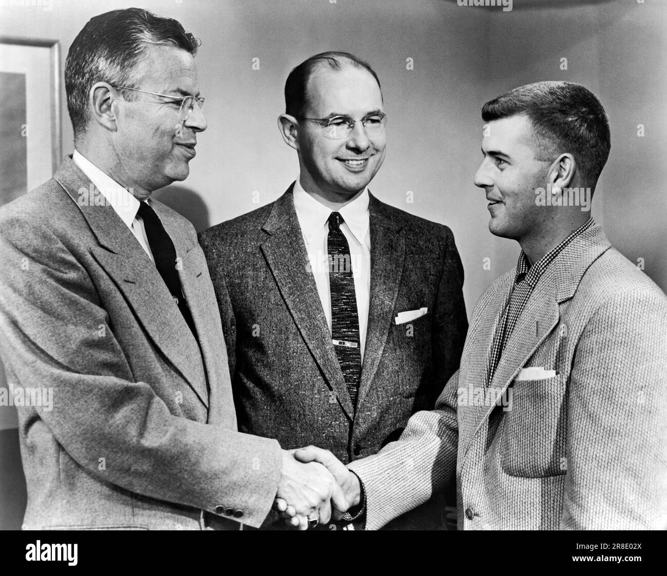 United States: c. 1958. A young man is greeted by an older man in a ...
