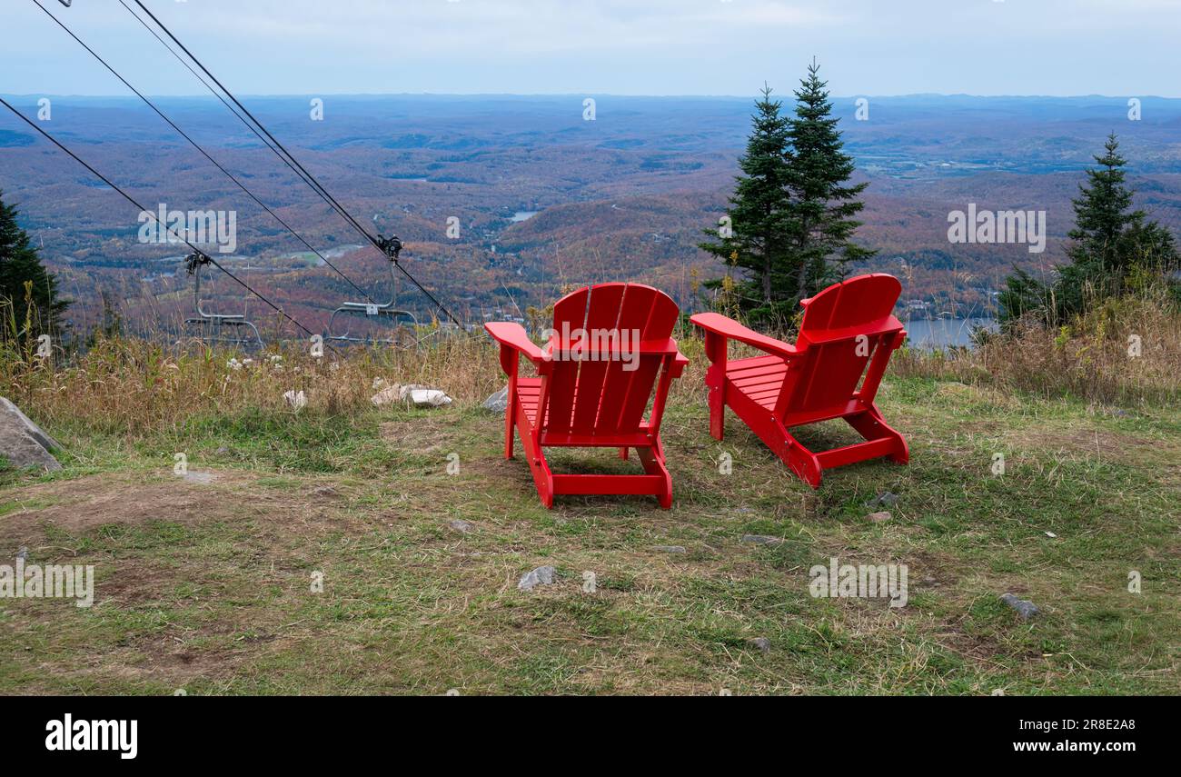 Two red chairs at Mont Tremblant summit, cable chair lift going down ...