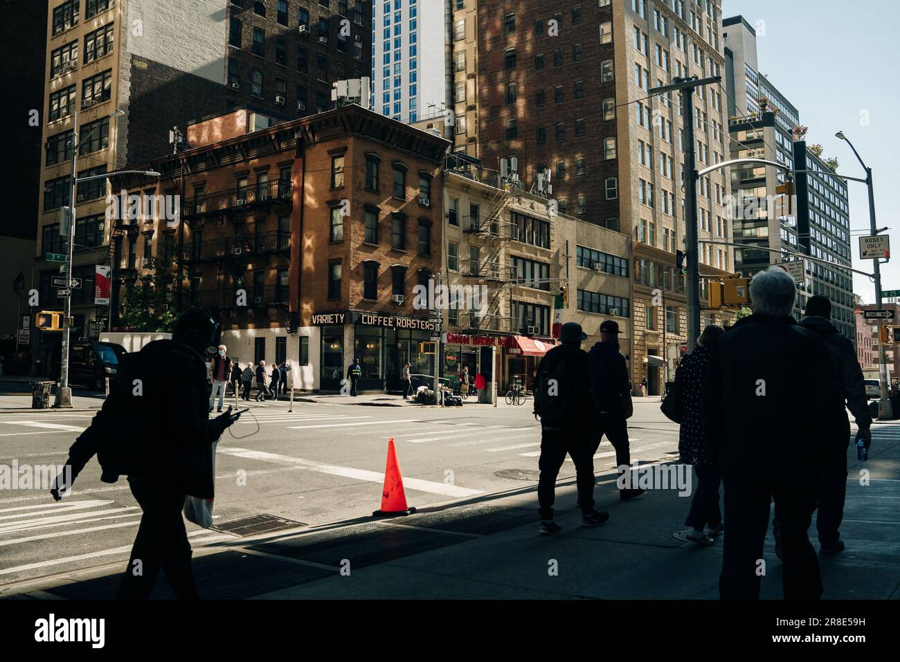 Busy street scene in New York City with groups of people walking across ...