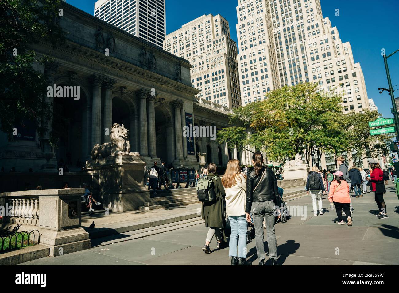 Busy street scene in New York City with groups of people walking across ...