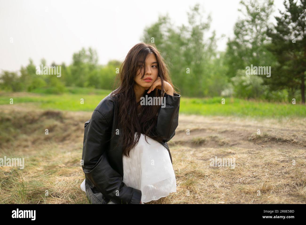 Portrait of teenage girl (16-17) crouching in nature Stock Photo - Alamy