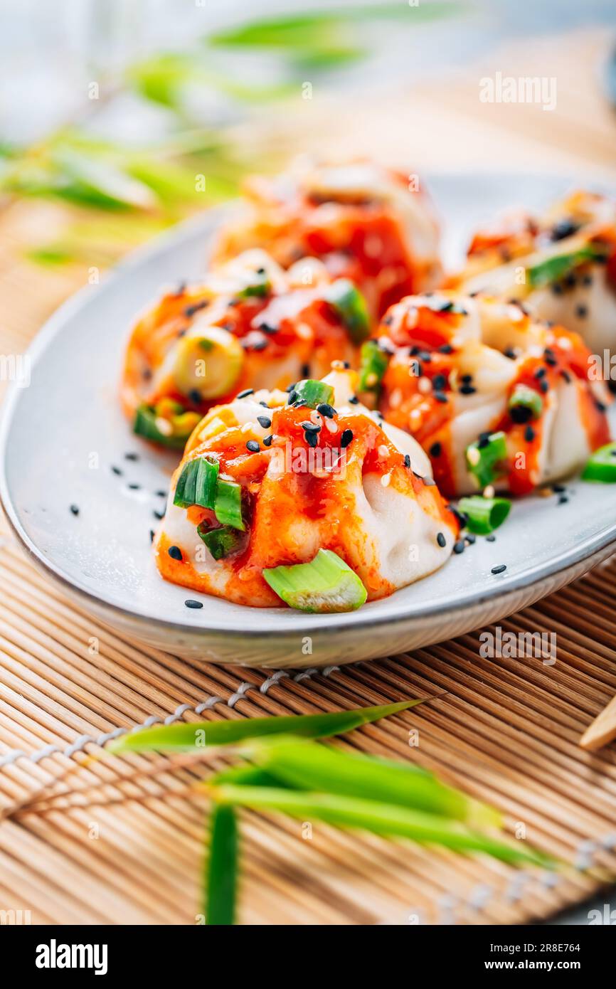 Steamed dumplings Dim Sum with hot Sriracha sauce and green onions and ...