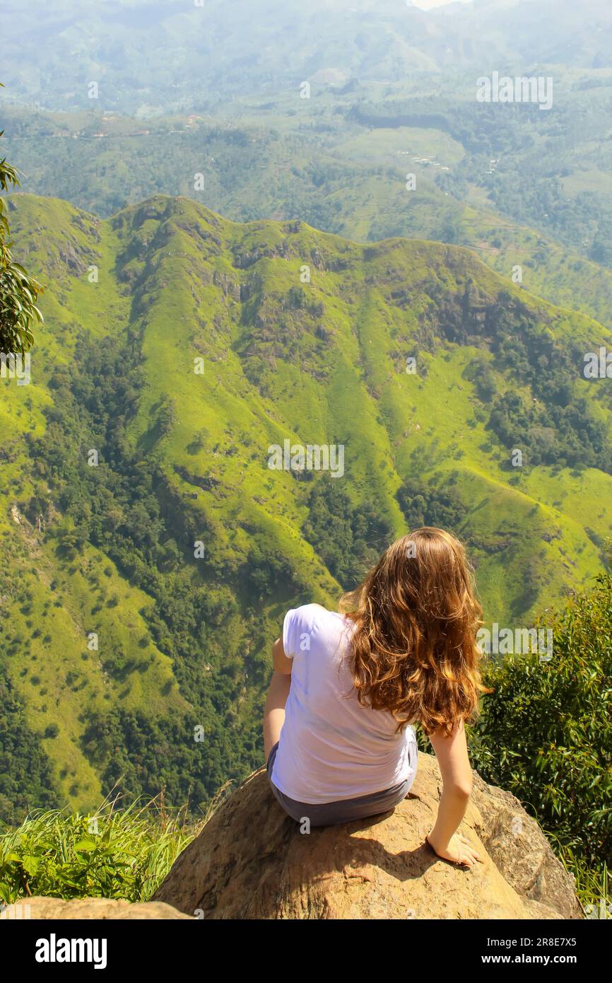 Tracking tourist adventure. Woman sitting on the top of Ella rock, Sri ...