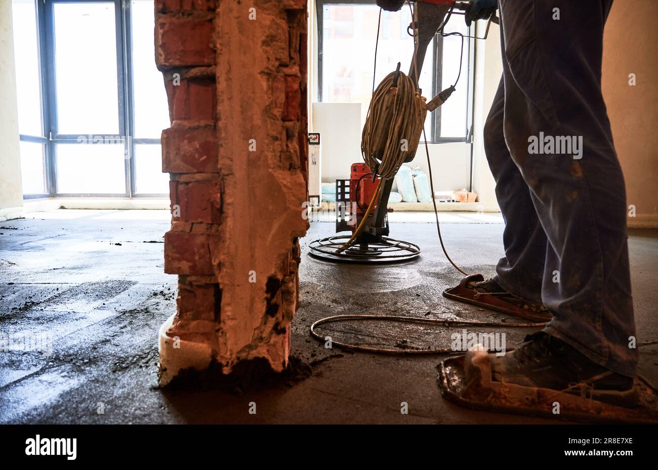 Close up view worker using troweling machine while screeding floor in ...