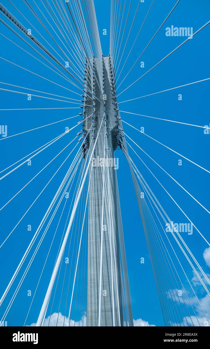 Modern bridge pylon against a blue sky. Detail of the multi-span cable ...