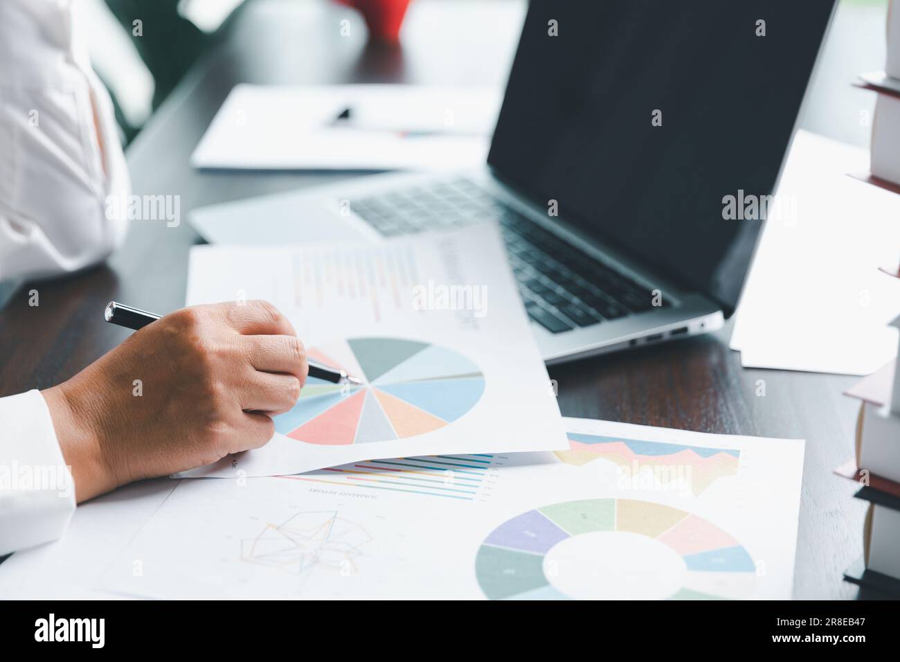 A young female of banking manger using calculator, computer laptop ...
