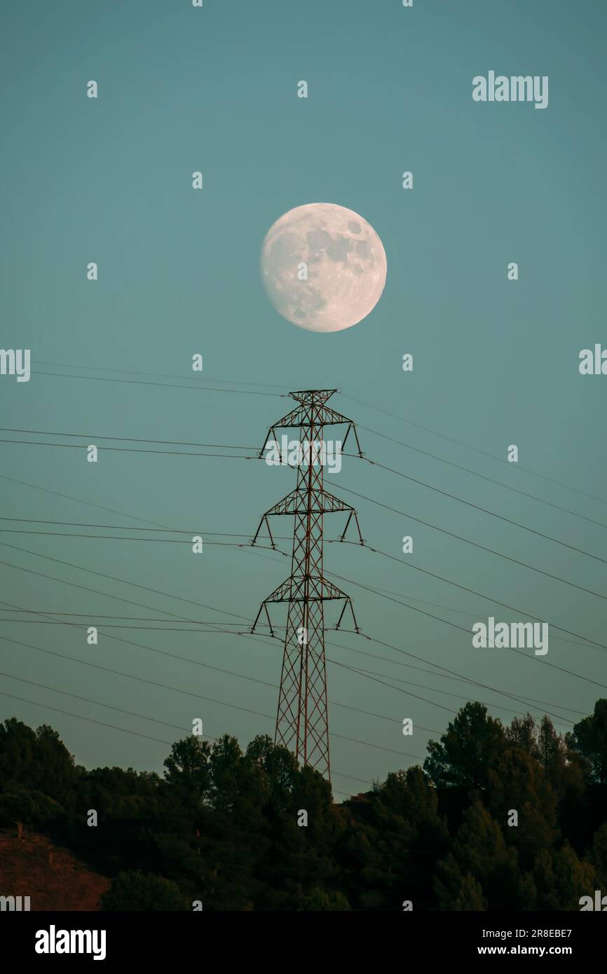 Full Moon over Power Pol and Power lines during golden hour in Spain ...