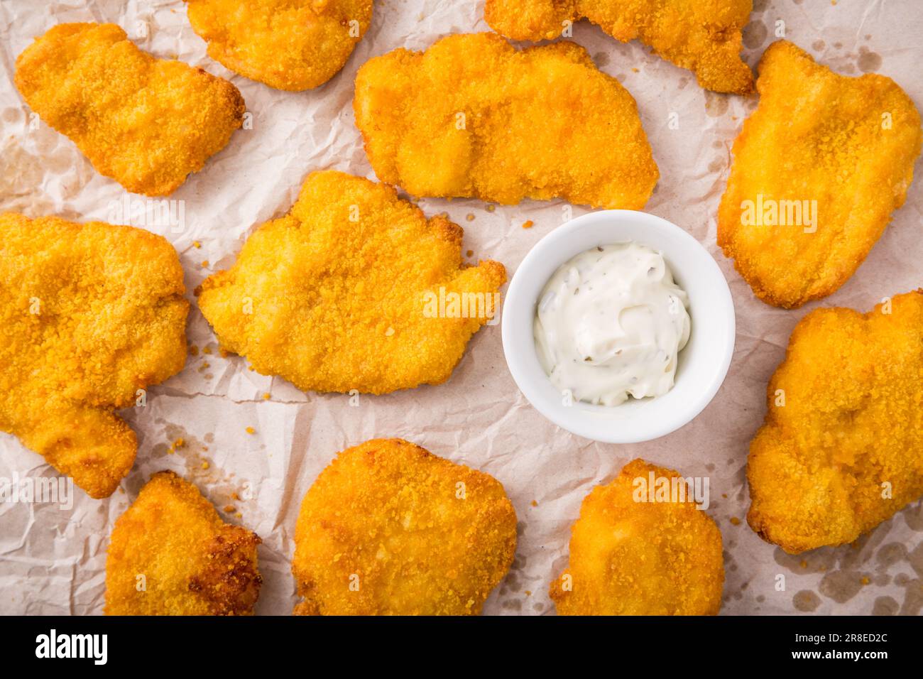 Small chicken schnitzel on baking sheet with herb mayonnaise Stock ...